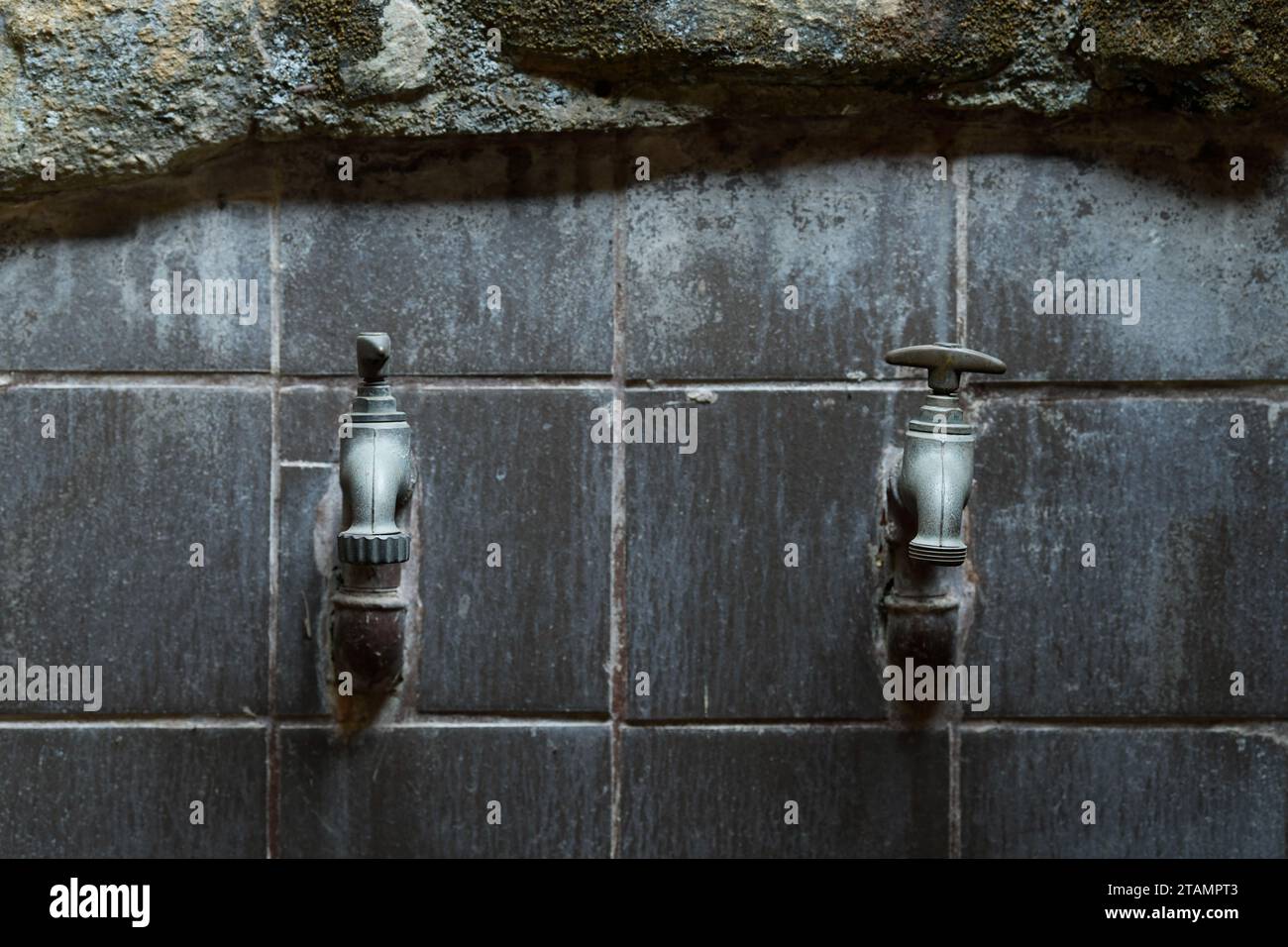 Dry faucet on tile wall, two water taps, drought concept, background ...