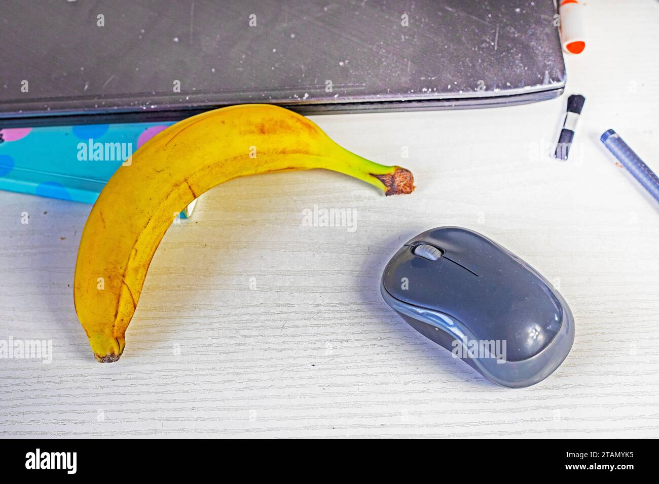 banana on the desktop near the computer mouse and laptop. Narbote snack ...