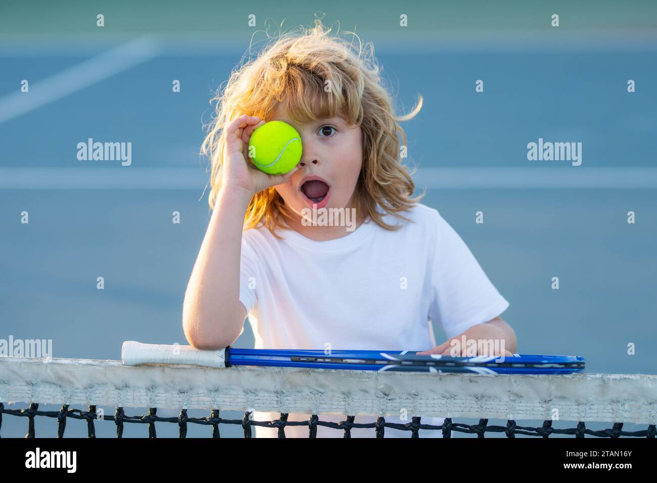 Child playing tennis on outdoor court. Child with tennis racket and ...