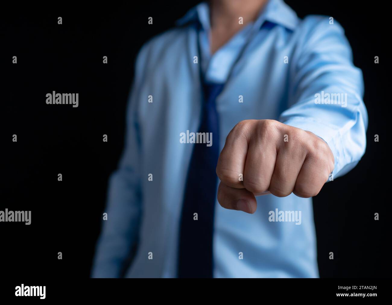 Businessman shows his fists in a fighting stance showing determination ...