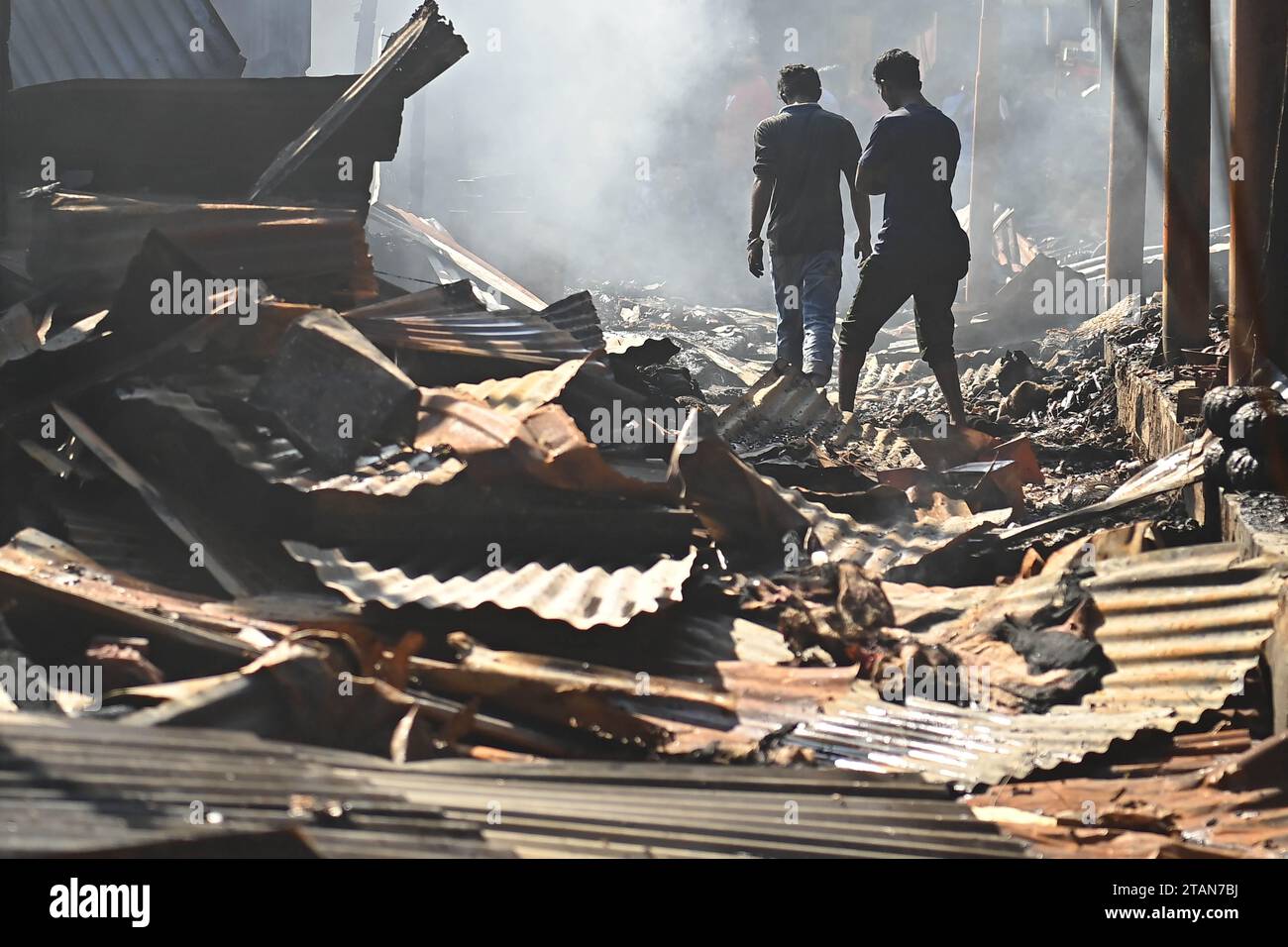 Shop owners and vendors are seen in front of their burnt shops and ...