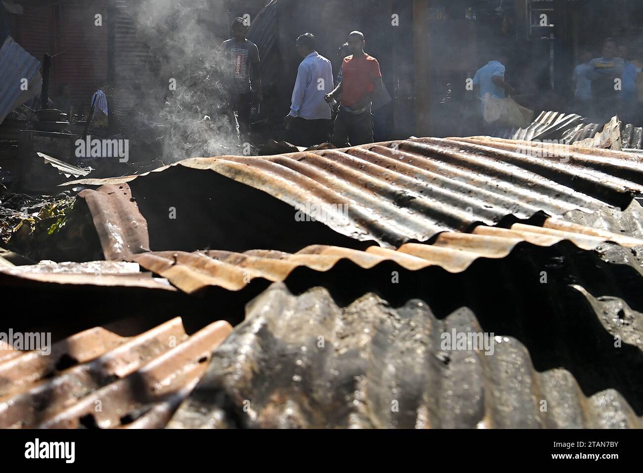 Shop owners and vendors are seen in front of their burnt shops and ...