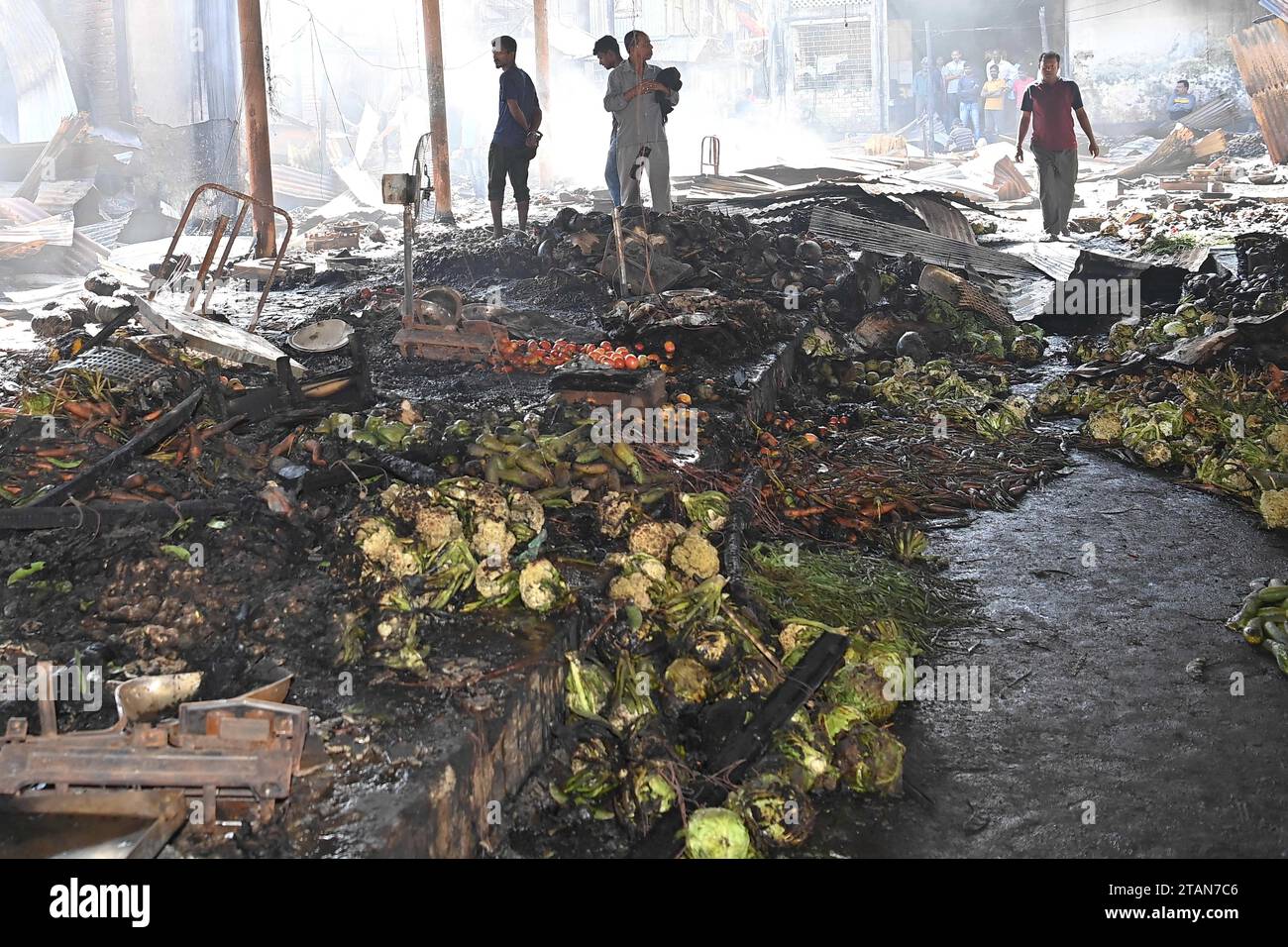 Shop owners and vendors are seen in front of their burnt shops and ...