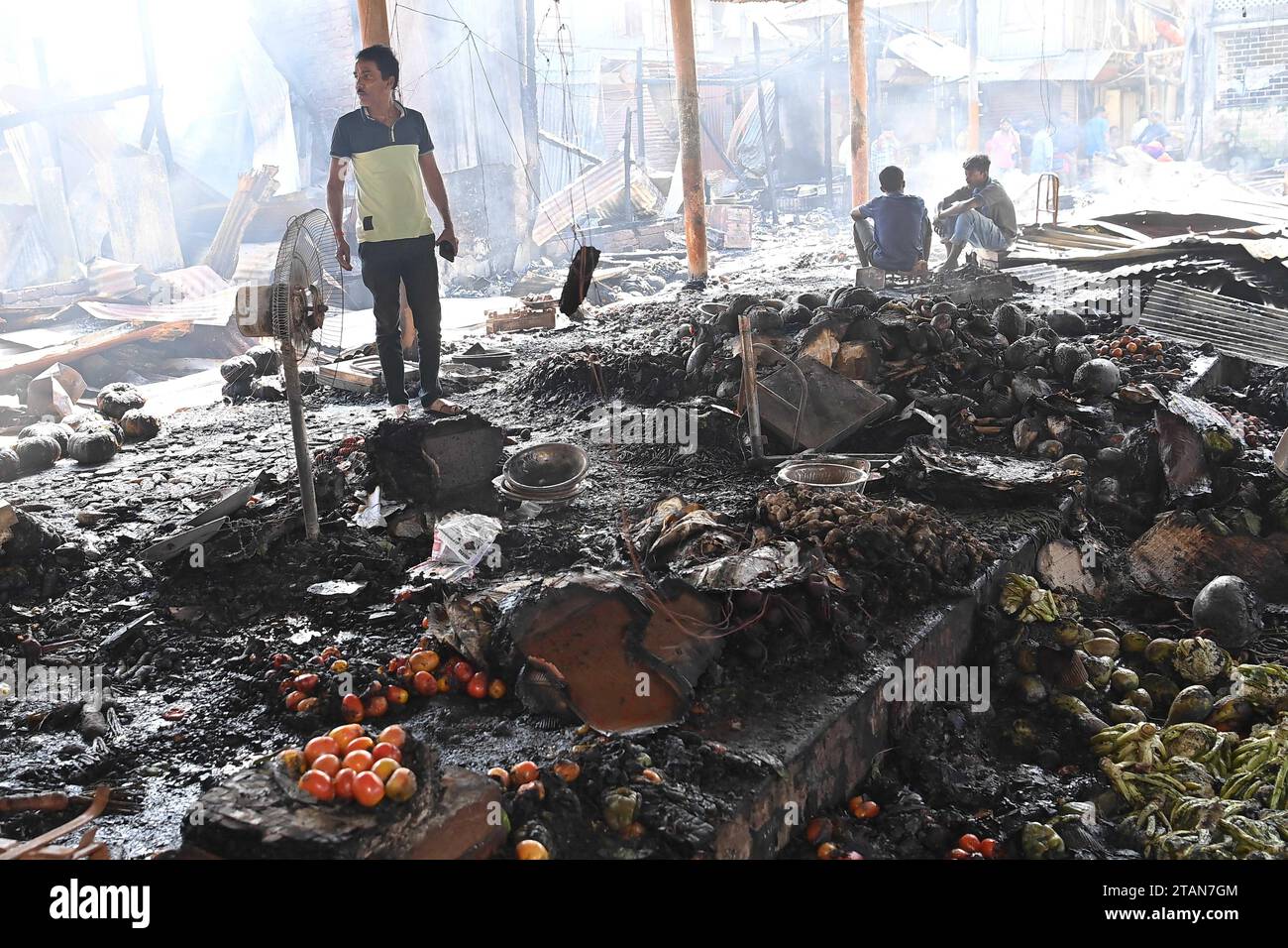 Shop owners and vendors are seen in front of their burnt shops and ...