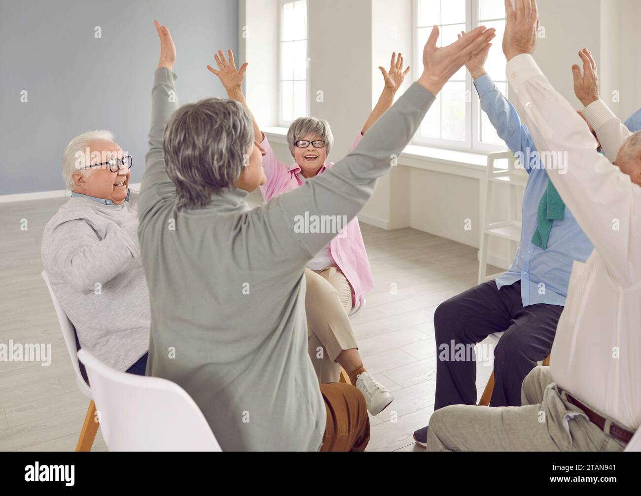 Senior people talking on therapy session at nursing home holding hands ...