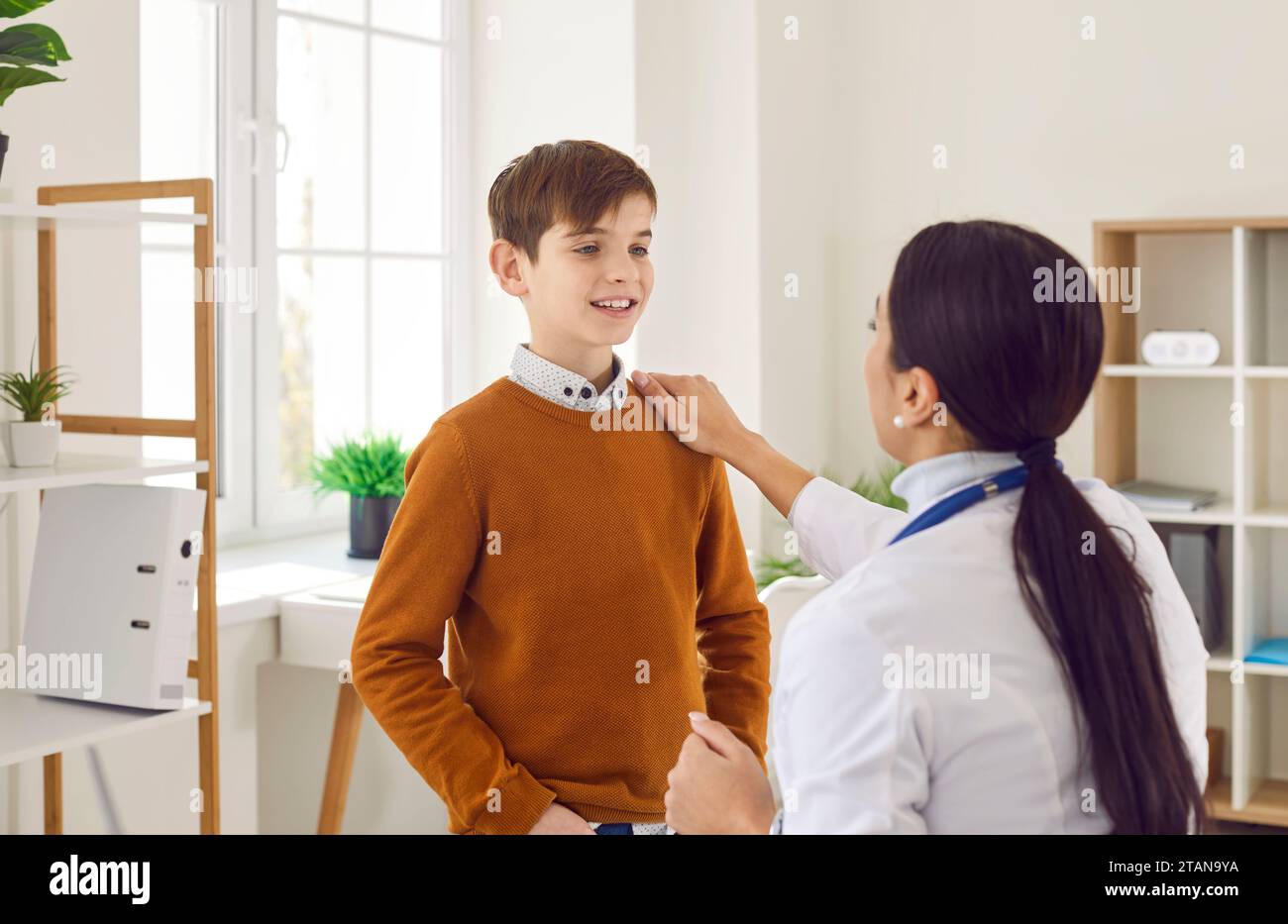 Female doctor talking with a child boy patient during medical ...