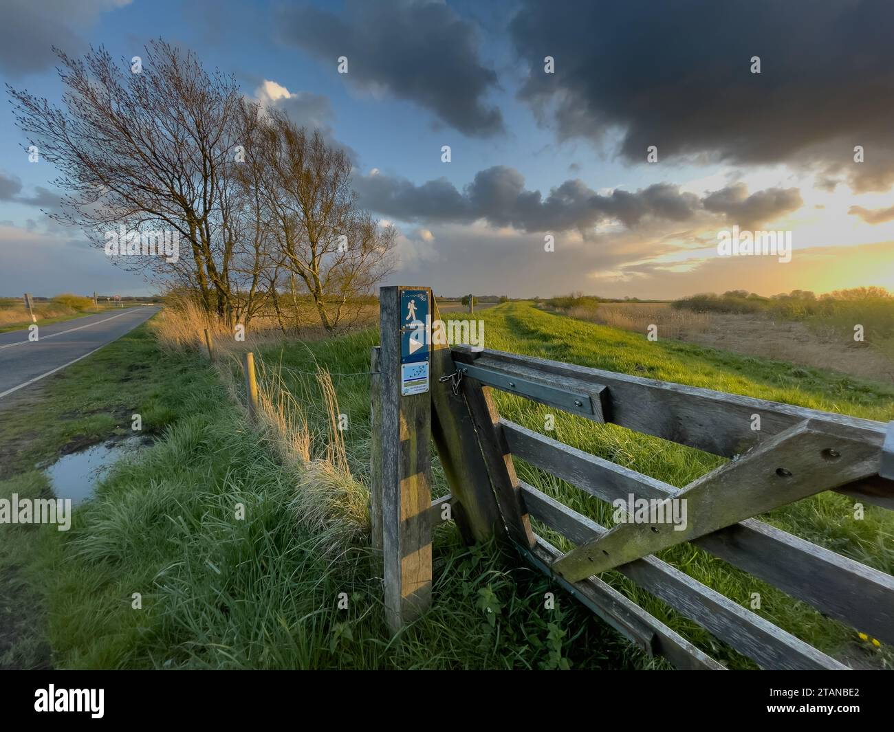 Wide angle shot of a gate leading to a hiking trail on a dike with ...