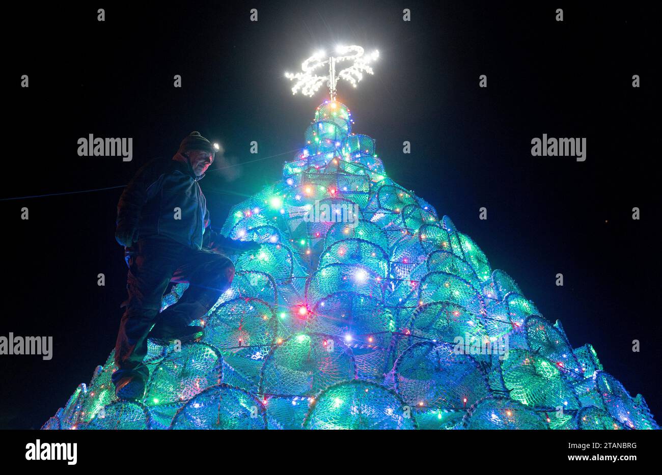 Gordon Wink checks the lights on the fishing creel Christmas tree he helped to design and build ...