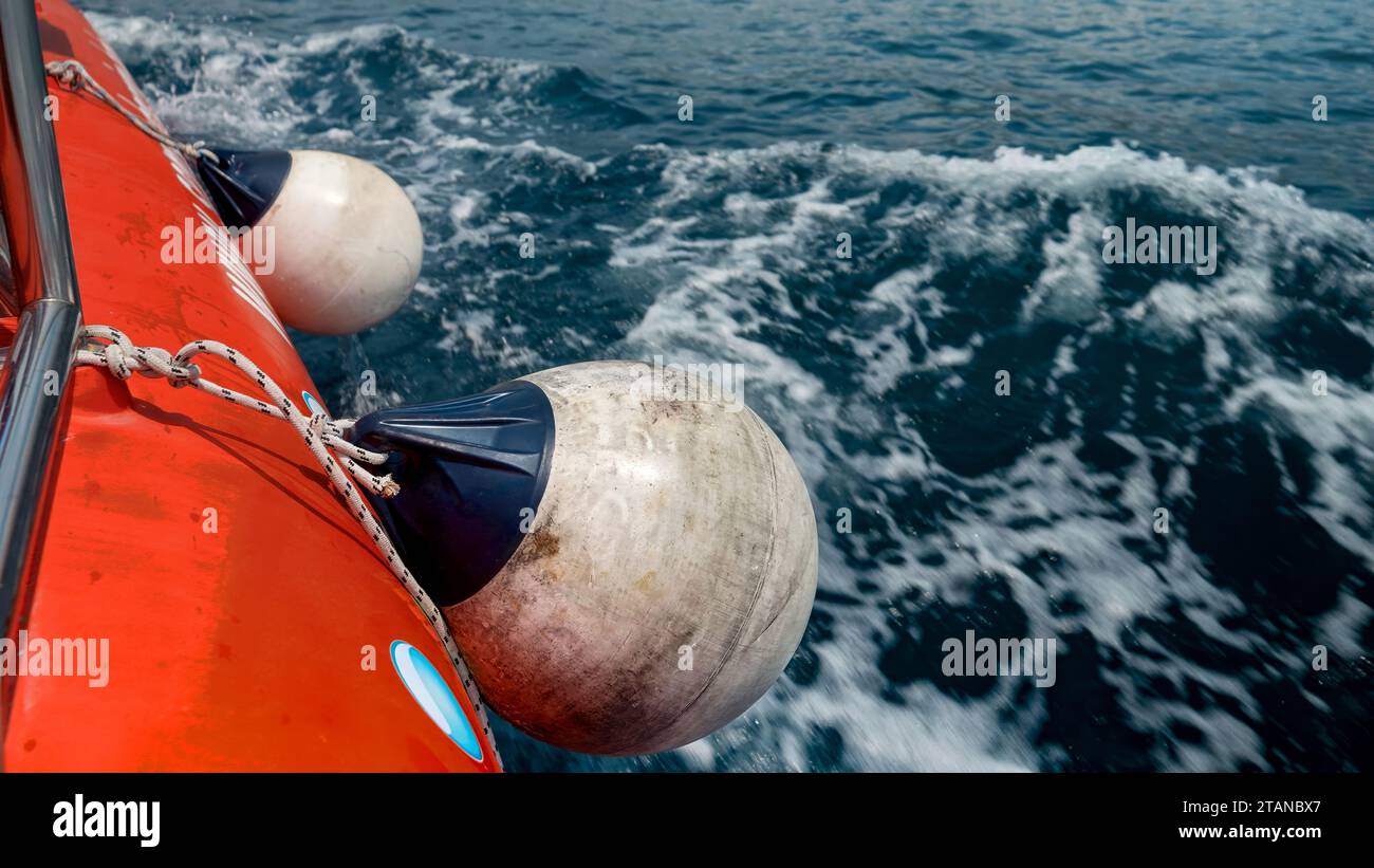 Side of the red life saving rescue boat sailing in cold ocean waves ...