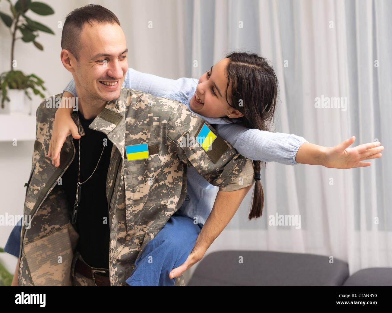 Father in Ukrainian military uniform and his daughter. Family reunion ...