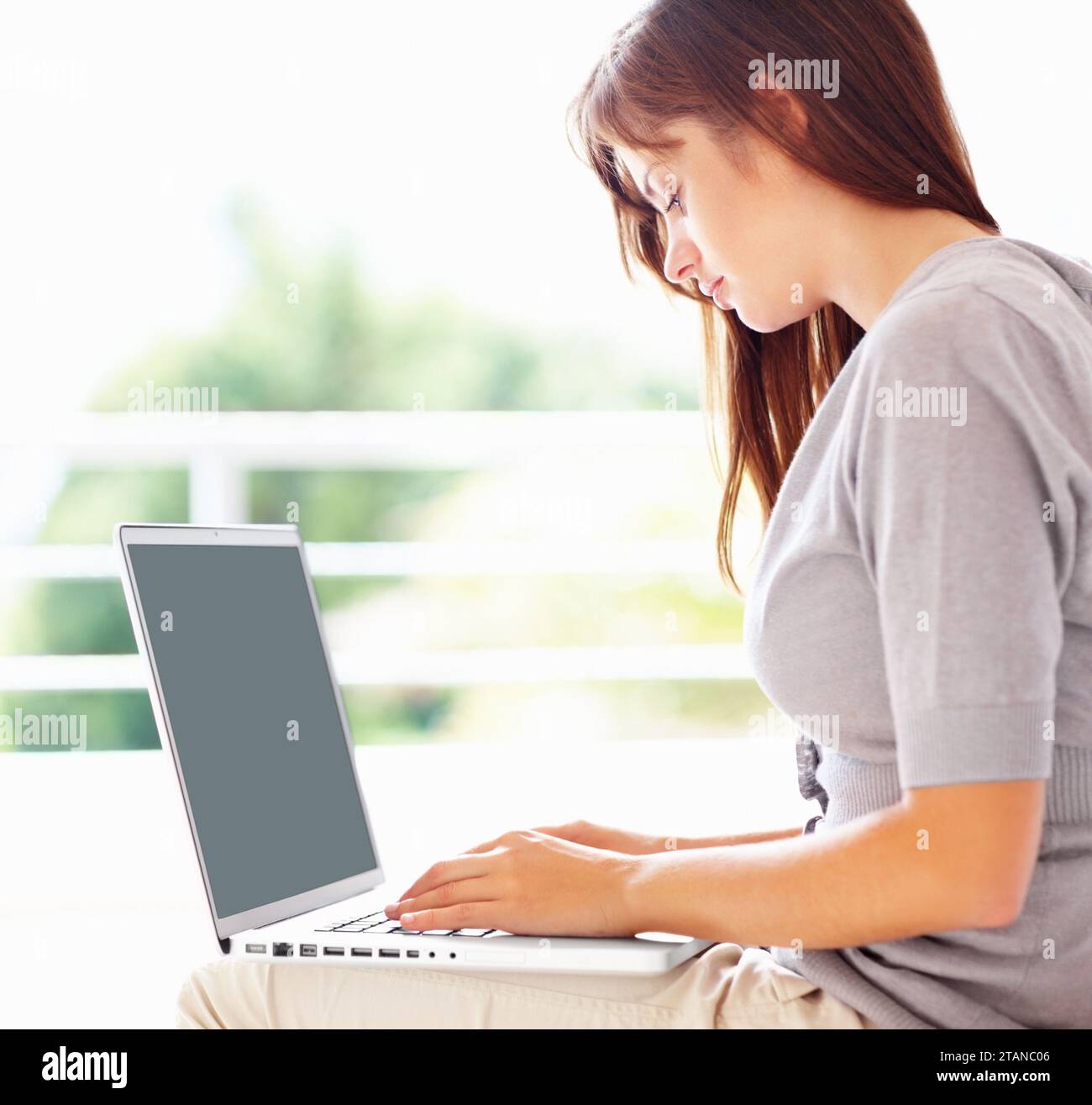 Laptop, typing and serious woman in home, remote work or social media ...