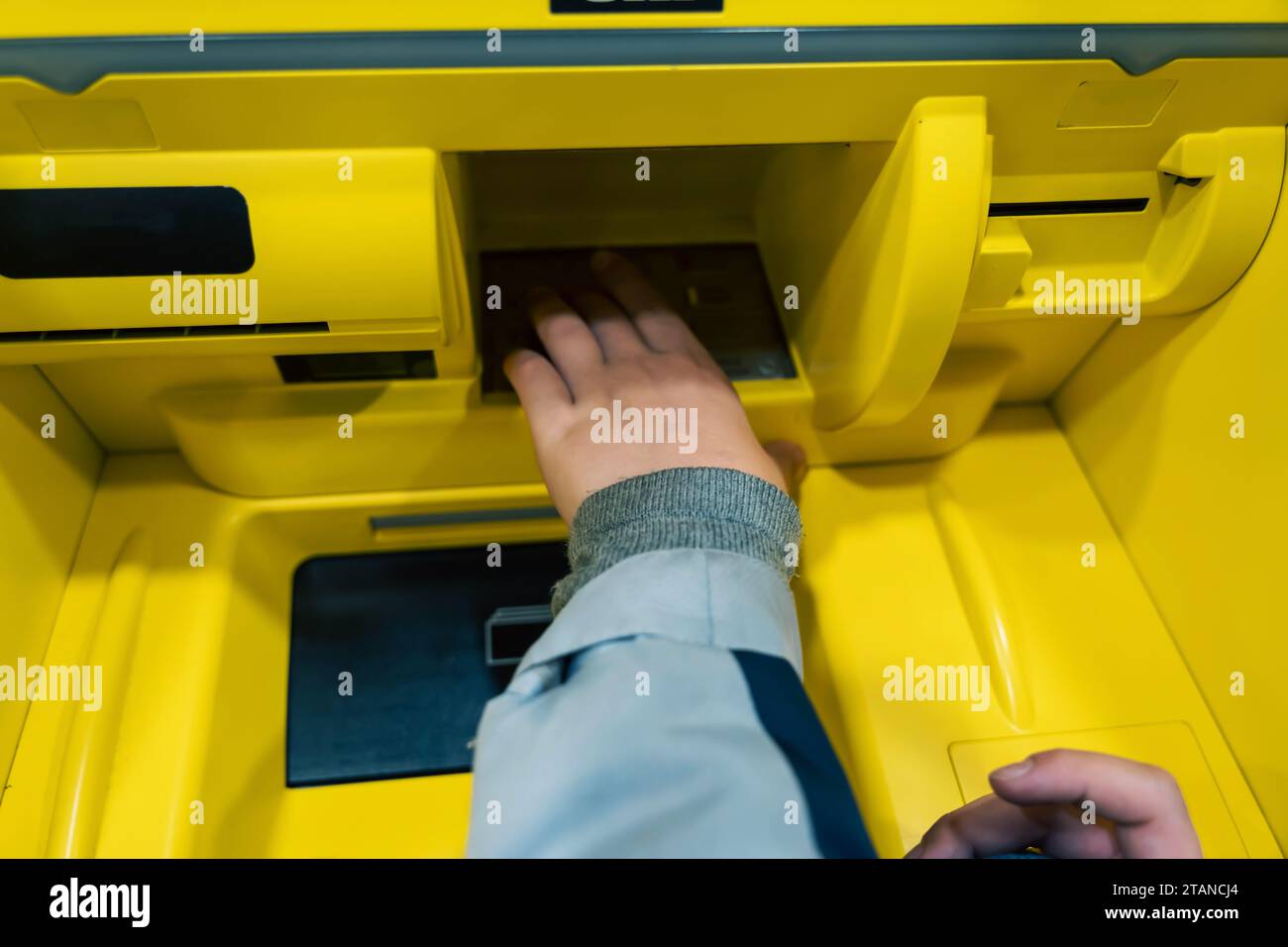 A close-up of a child's hand reaching for a push-button control panel ...