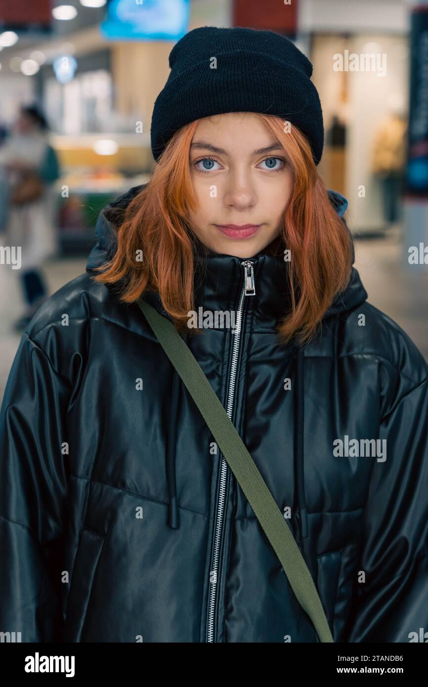 Close-up portrait of a fashionable teenage girl with striking red hair ...