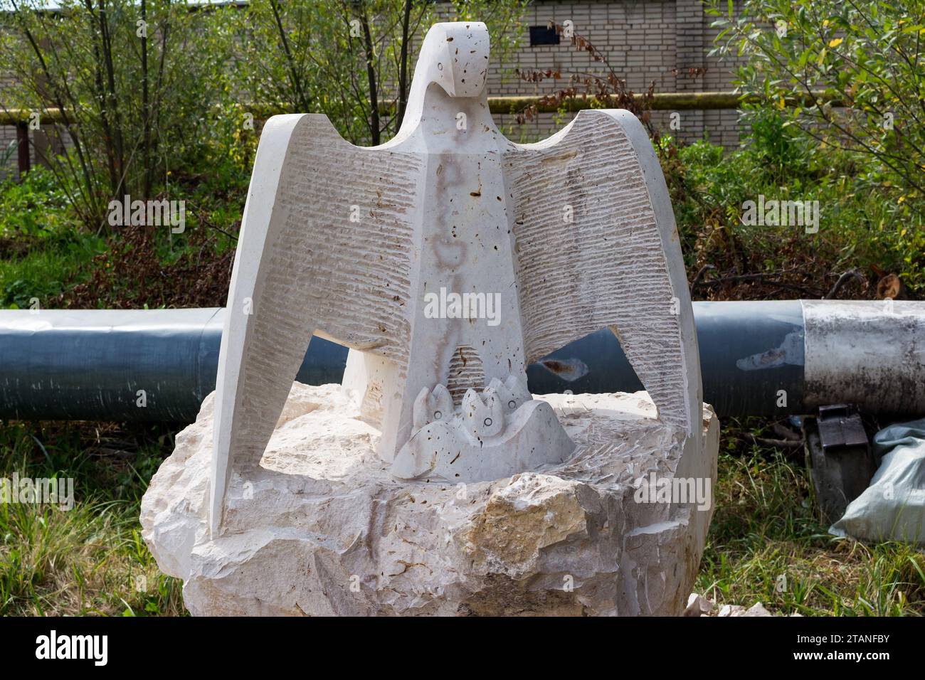 A sculpture of a bird feeding its chicks carved from limestone rock ...
