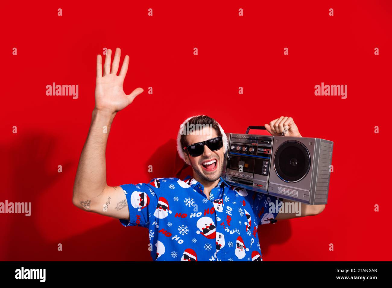 Portrait of young guy student raised palm up clubber carry tape player ...