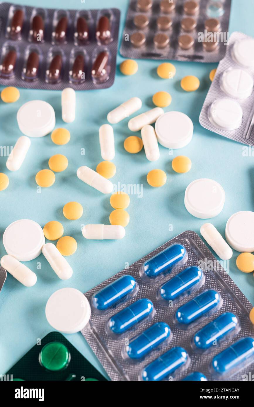 many different blisters with tablets on blue background. Assorted ...