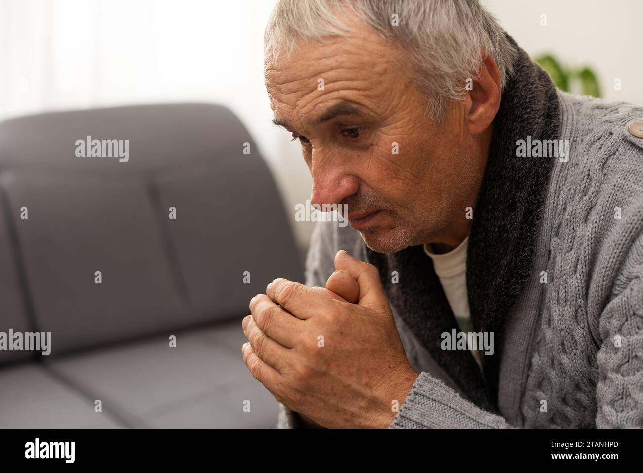 Portrait praying senior man against white background Stock Photo - Alamy