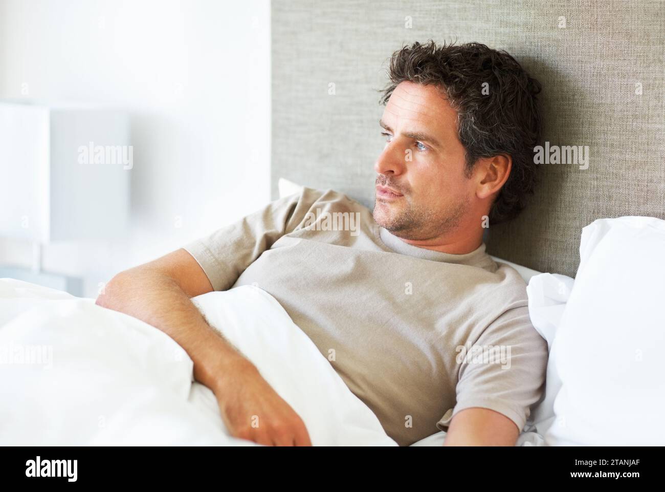 Thinking, depression and man in bed with mental health crisis, disaster ...