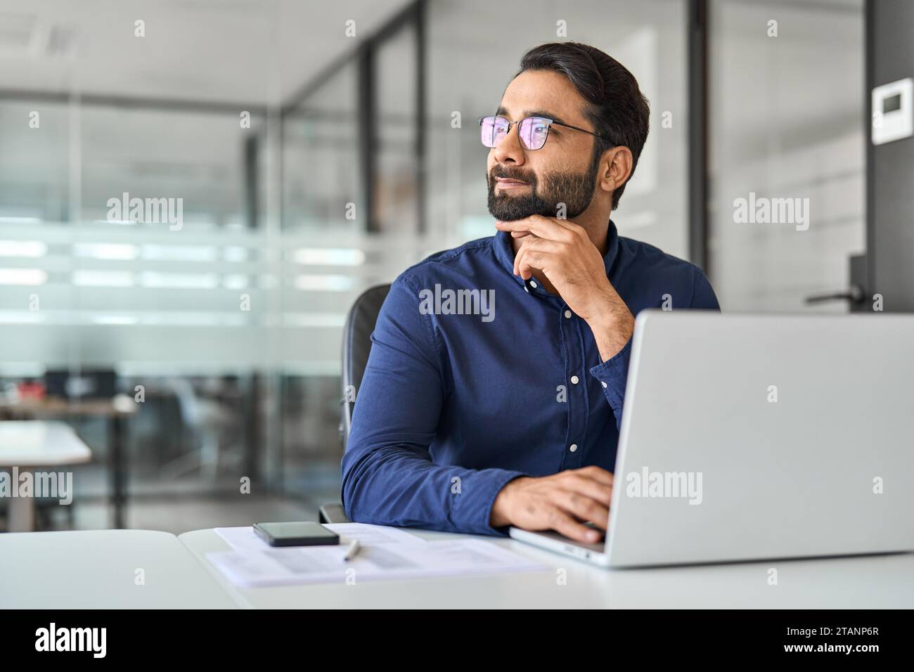 Happy Indian business man worker thinking looking aside working on ...