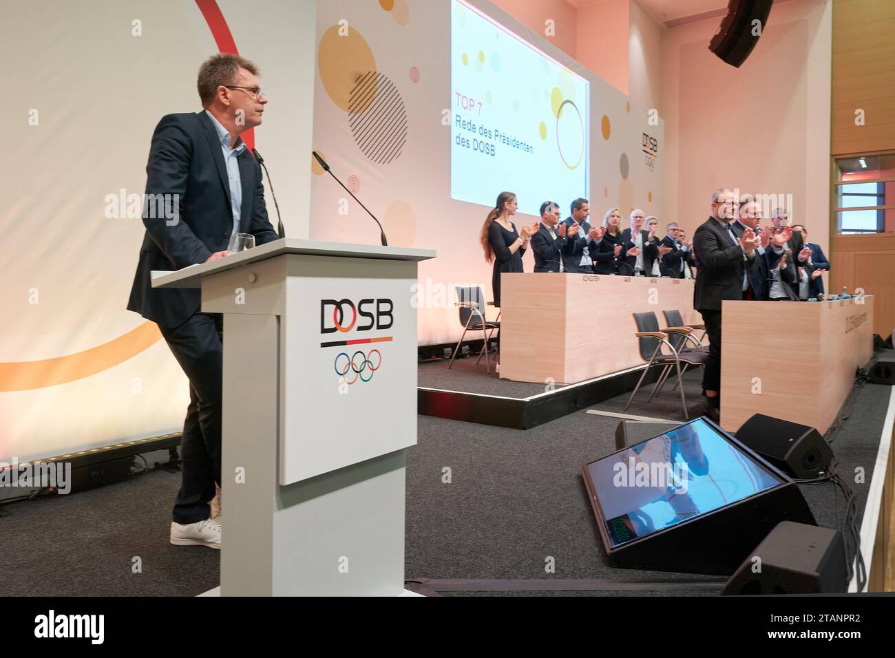 02 December 2023, Hesse, Frankfurt/M.: The podium reacts with a ...