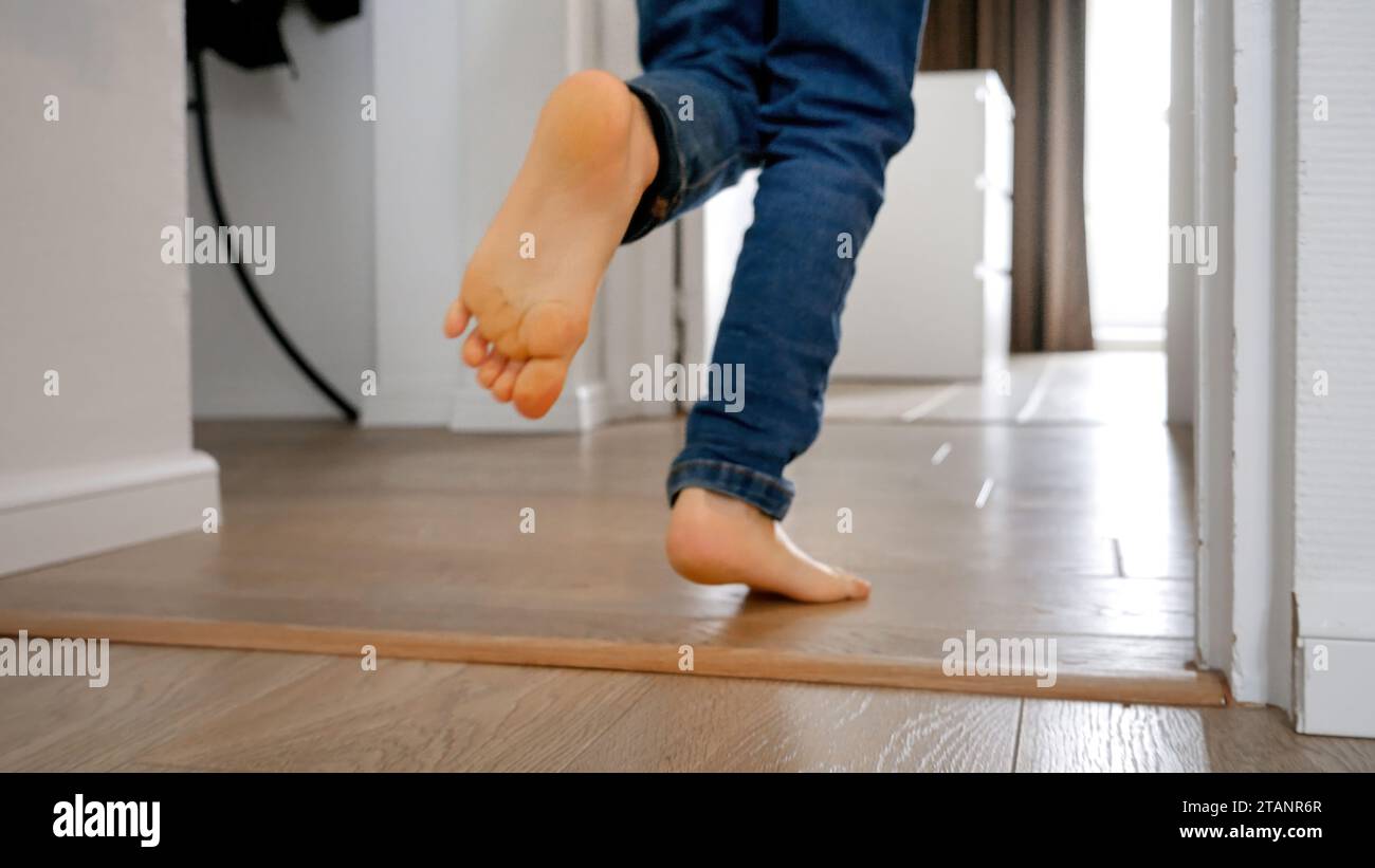 Little boy running down a long wooden corridor at home. Concept of a ...