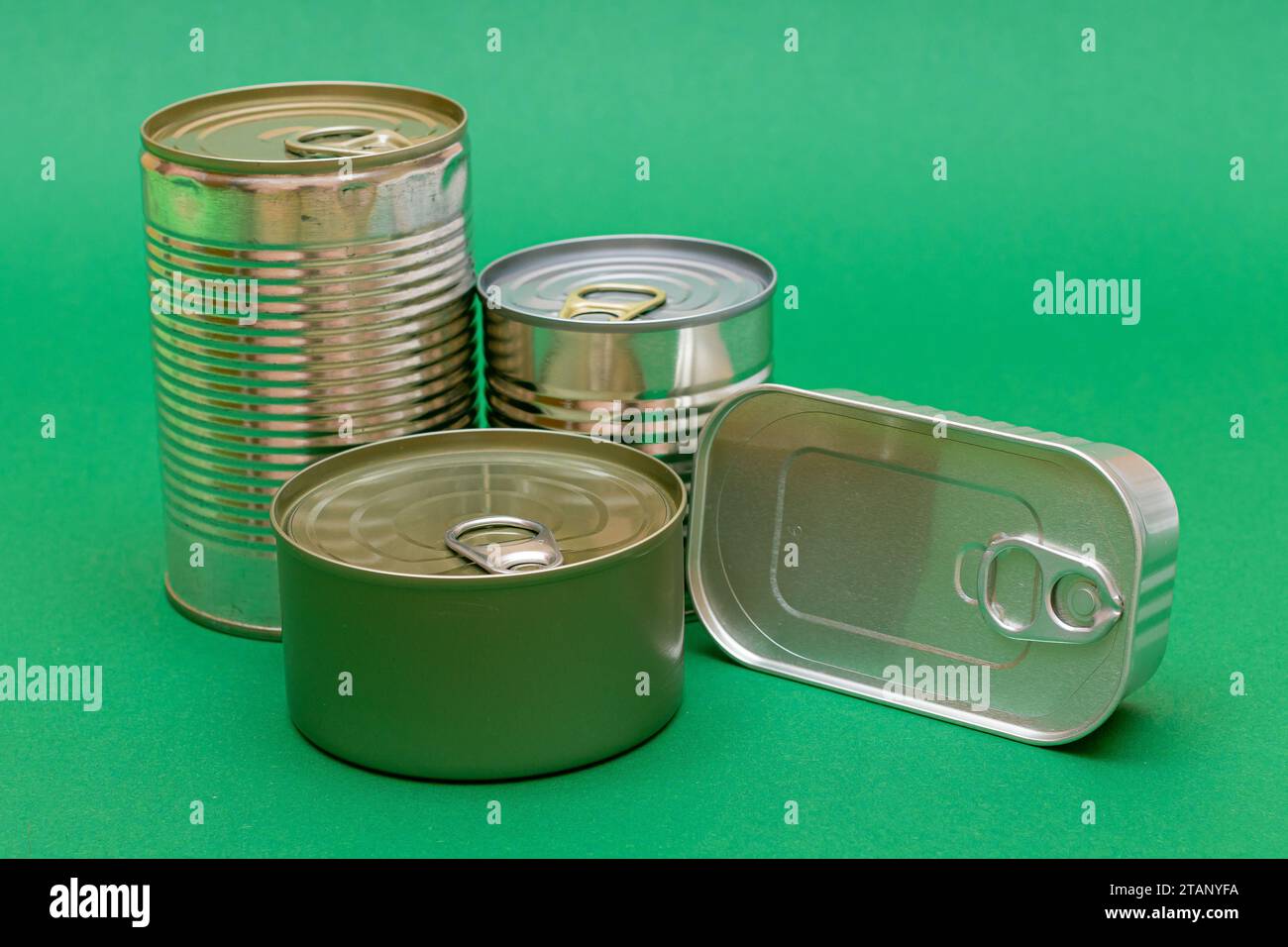 A Group of Stacked Tin Cans with Blank Edges on Green Background ...