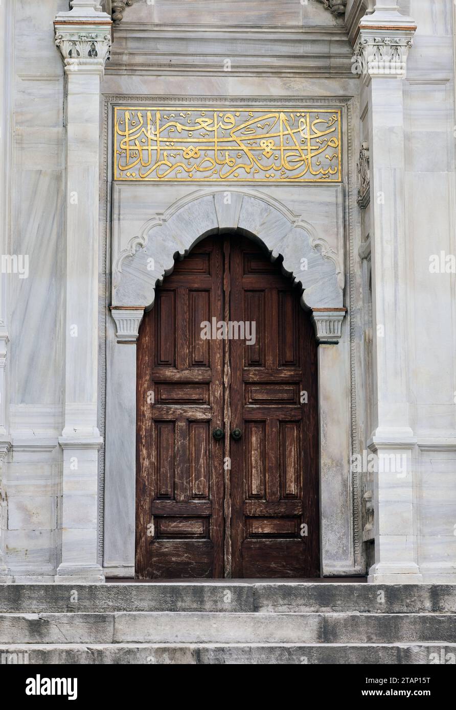 A rustic wooden door stands open, flanked by a stone staircase in ...