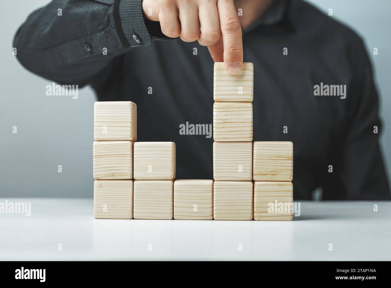 Hand putting and stacking blank wooden cubes on table with copy space ...