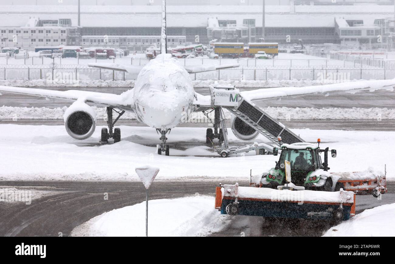 Munich, Germany. 02nd Dec, 2023. A snow plow drives in front of a plane ...