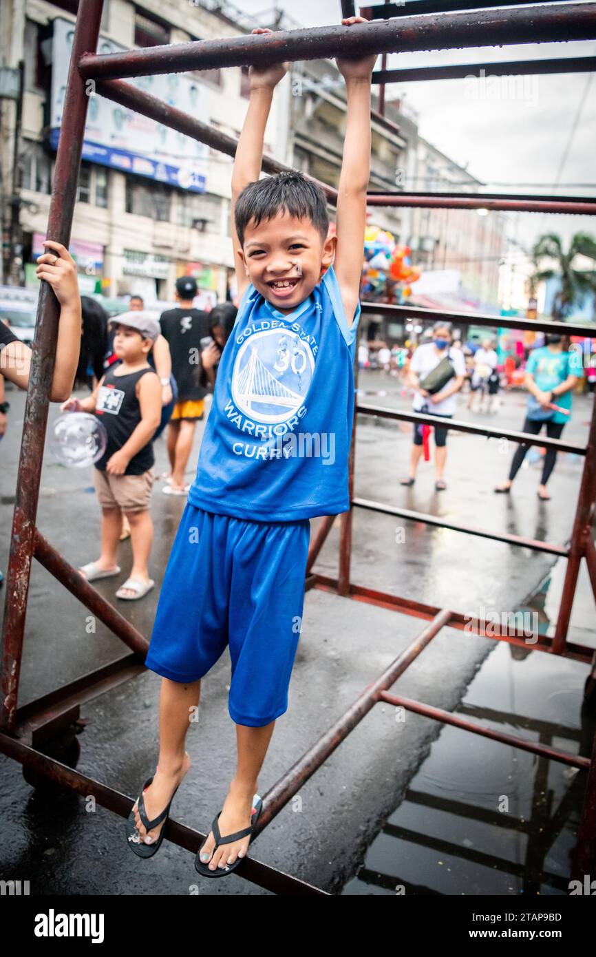 A young Filipino boy plays on a metal frame in Tondo, Manila, The ...