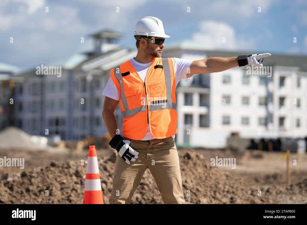 Builder in a hard hat working on a construction project at a site. A ...