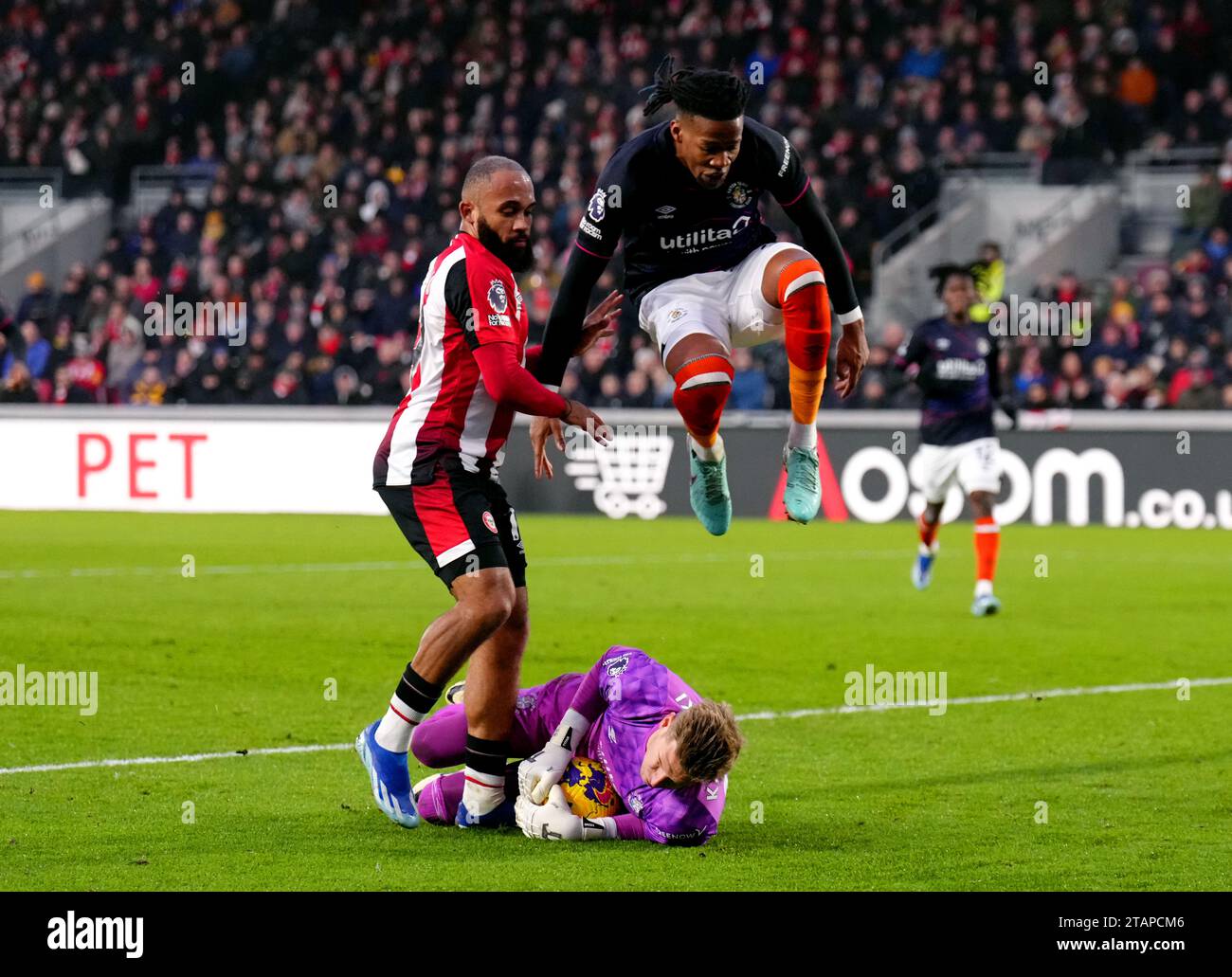 Luton Town goalkeeper Thomas Kaminski (floor) saves the ball from ...