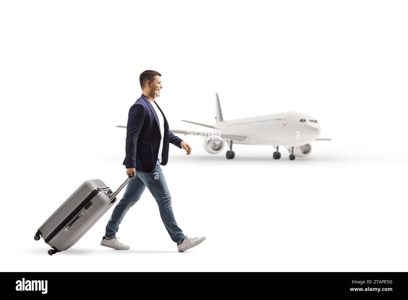 Full length profile shot of a man pulling a suitcase in front of a ...