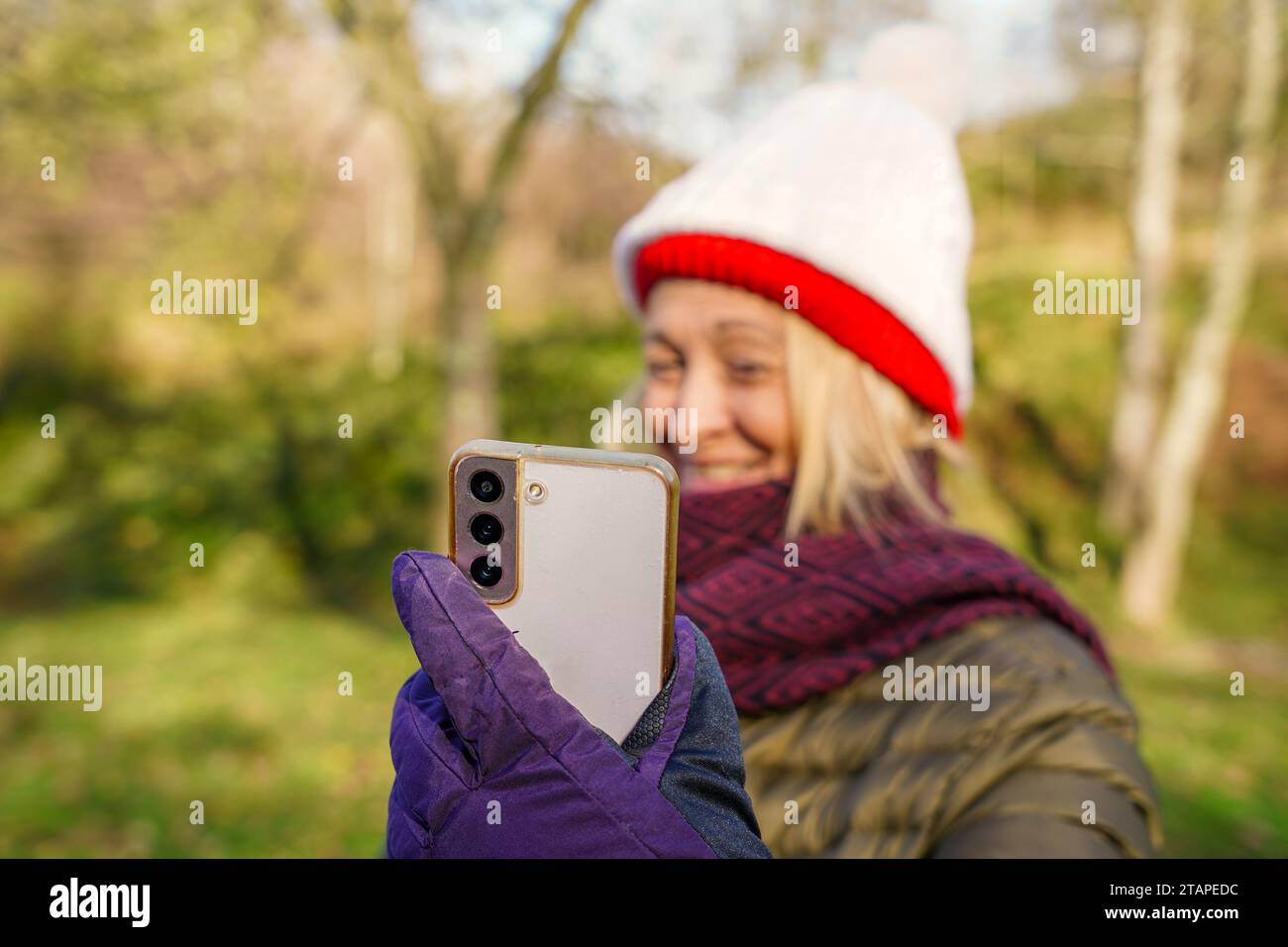 A flirtatious older woman taking a selfie with her mobile in wintertime Stock Photo - Alamy