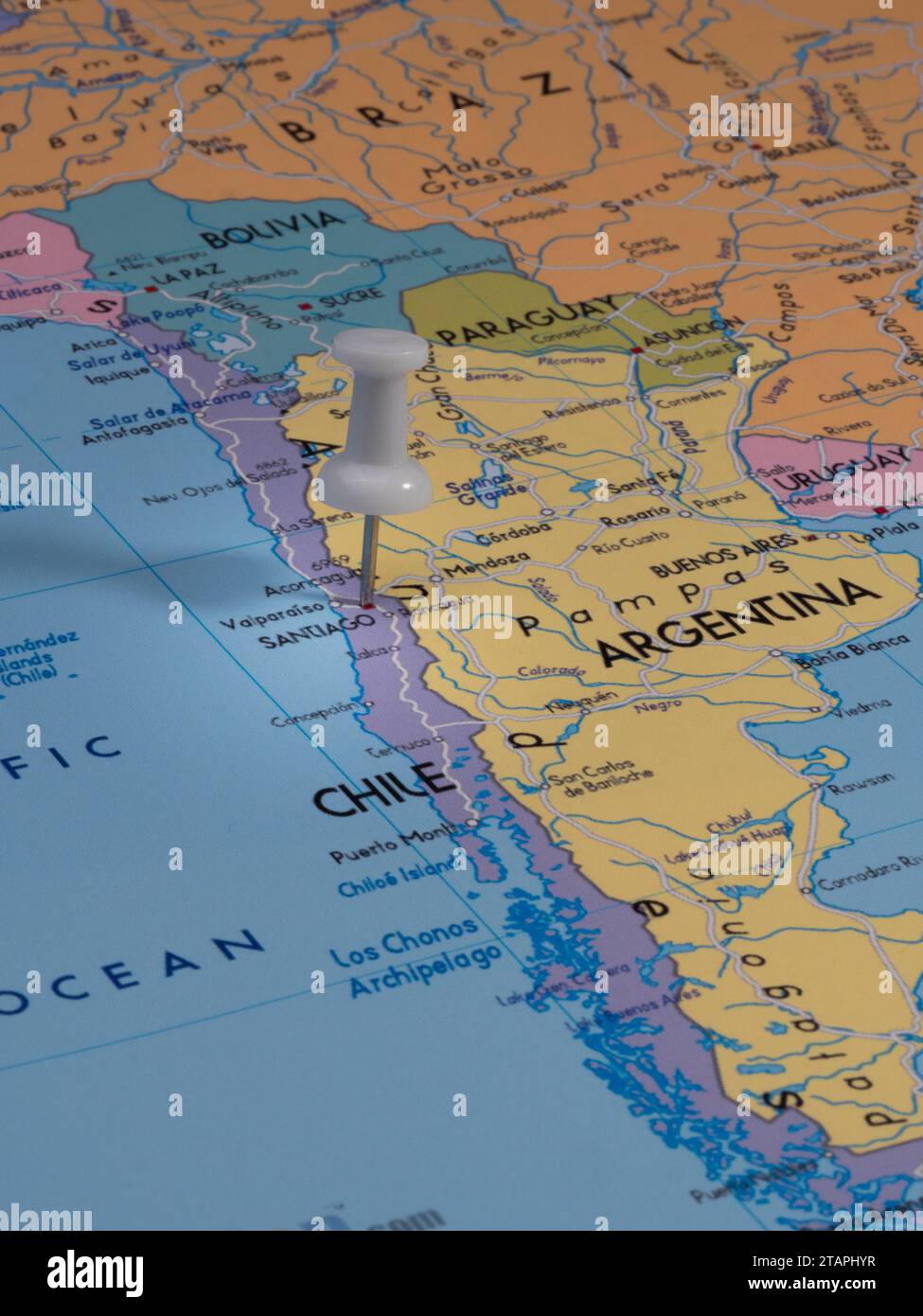 A close-up of a world map with a pin pointing to the location of Chile ...