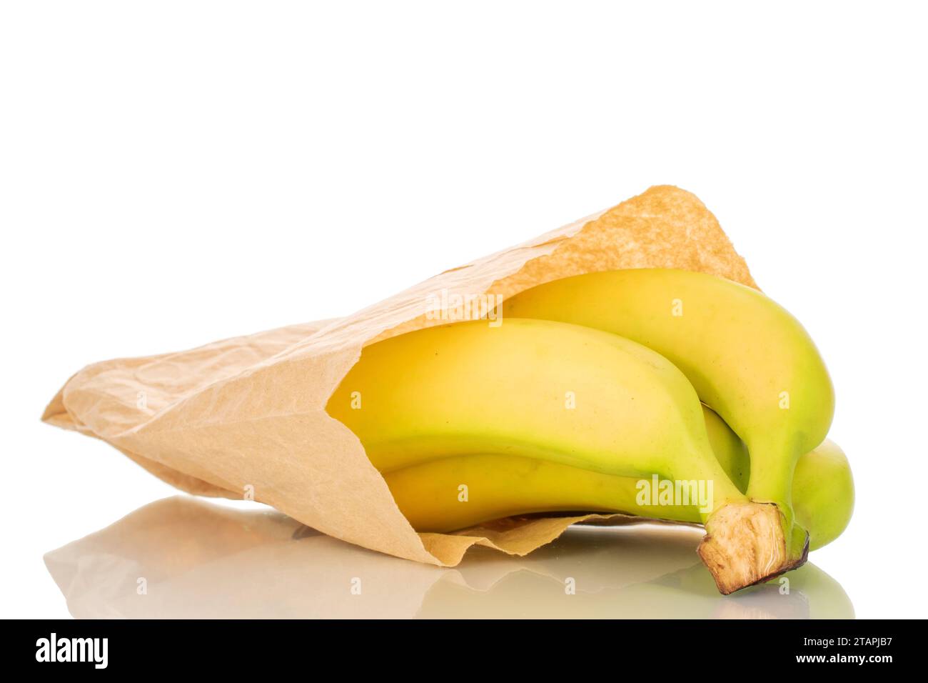 Several ripe bright yellow bananas with paper bag, macro, isolated on ...