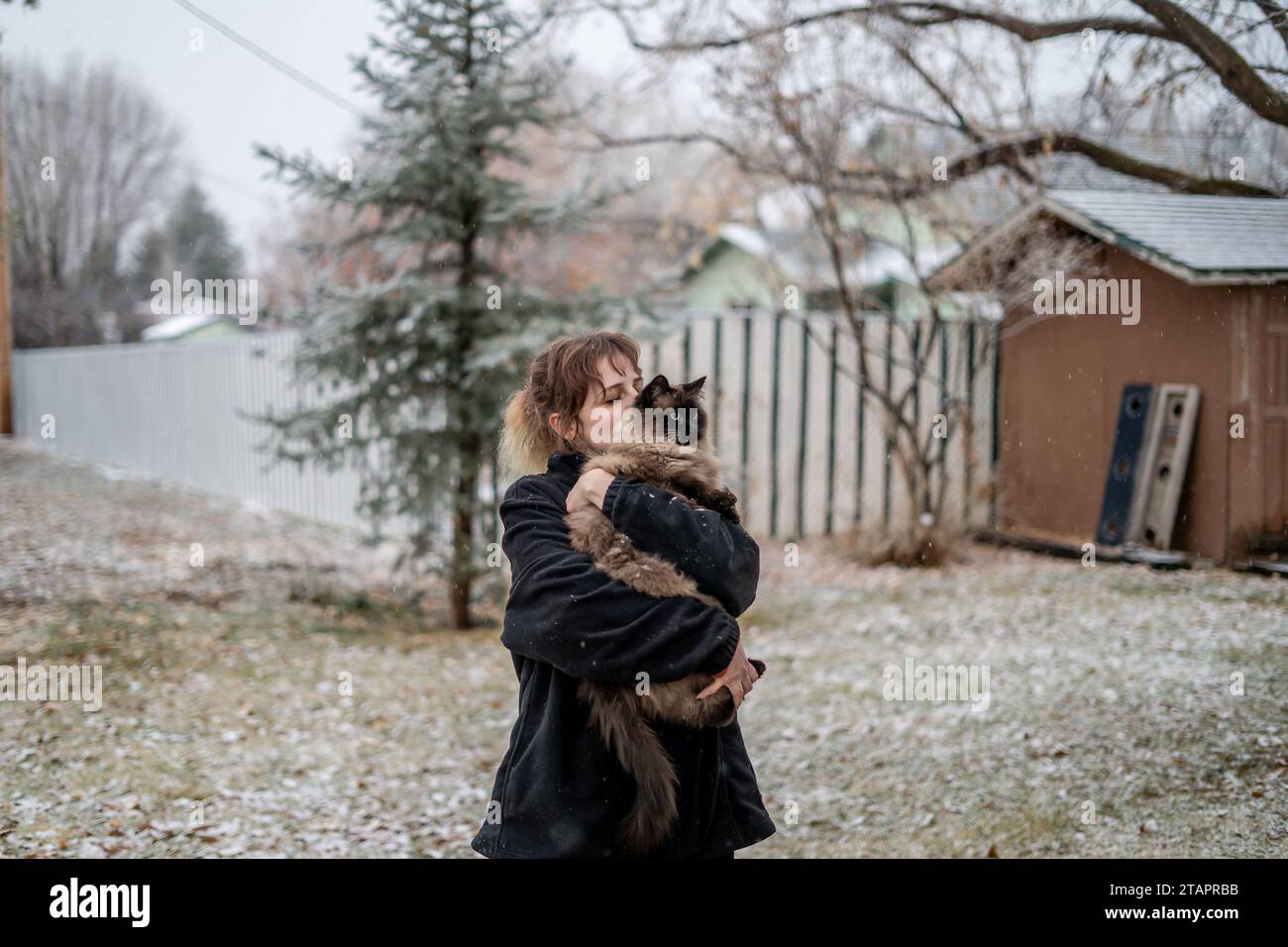 Young Girl in Jacket Outside Finds and Hugs Big Fluffy Siamese Cat in ...