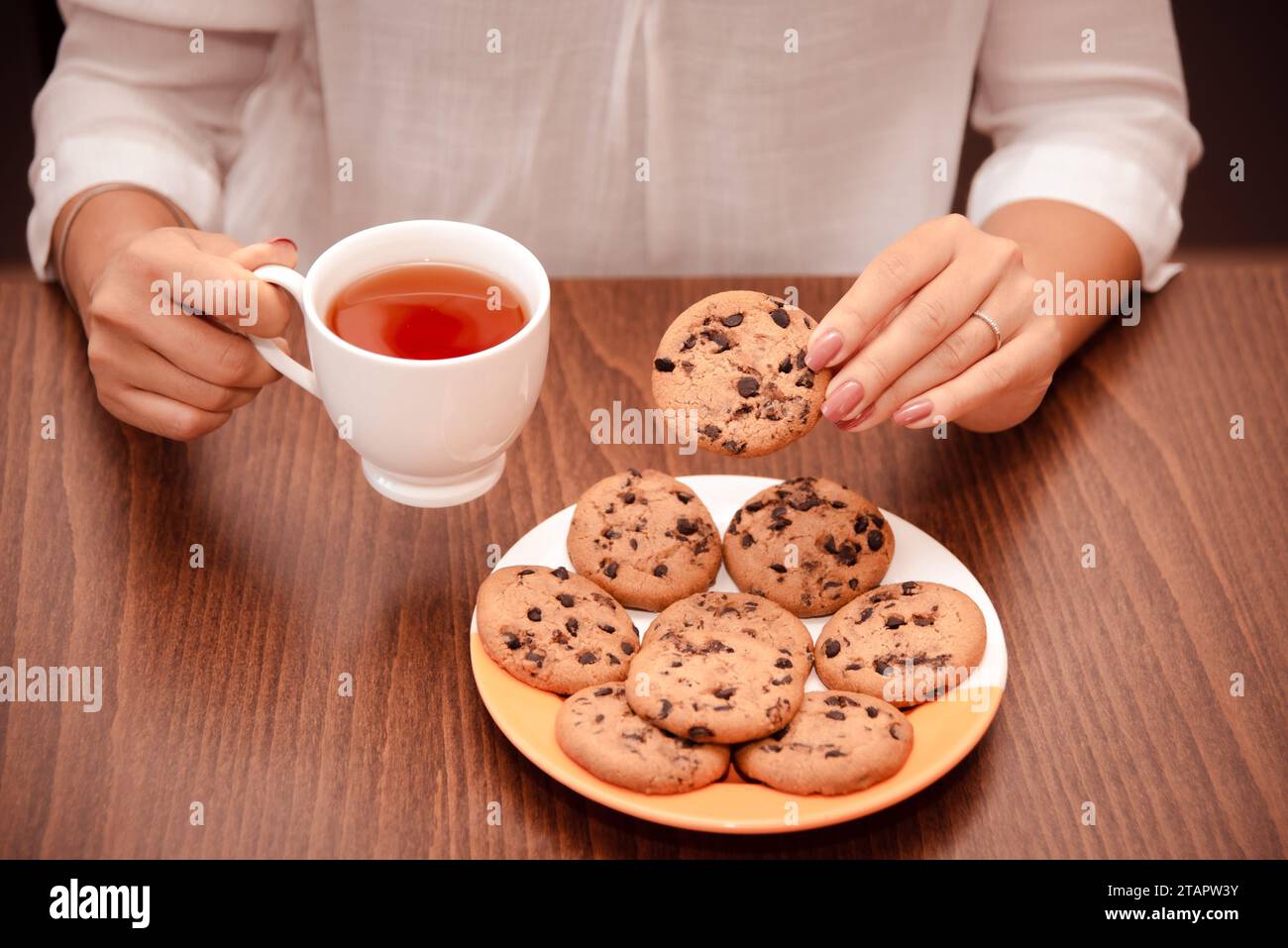 Woman eating biscuit in office hi-res stock photography and images - Alamy