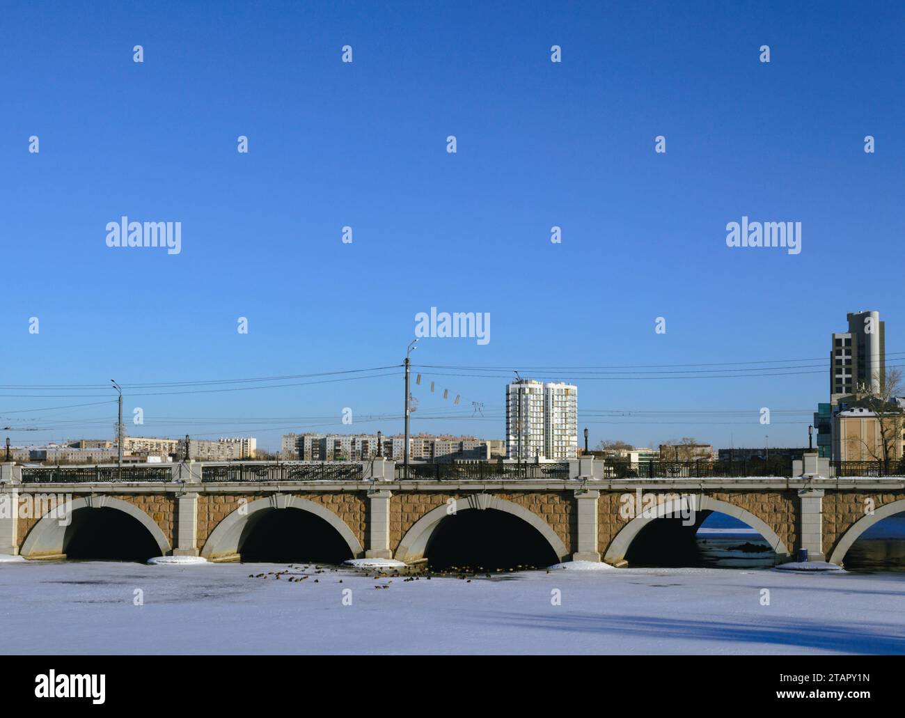 Close-up of the historic arch bridge and the frozen river below it ...