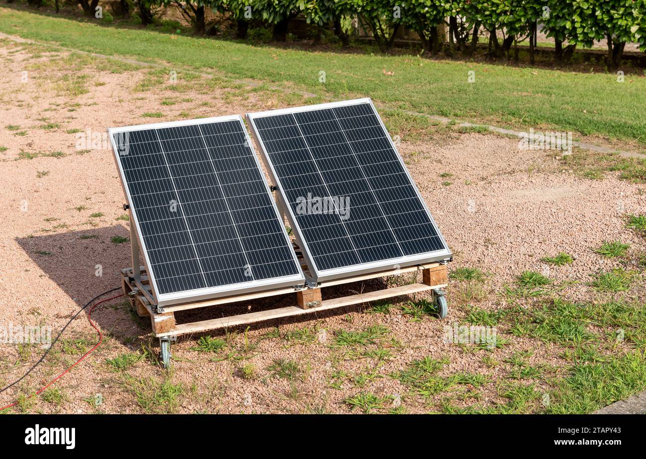 Photovoltaic panels on the wooden pallet in the home garden. Green ...