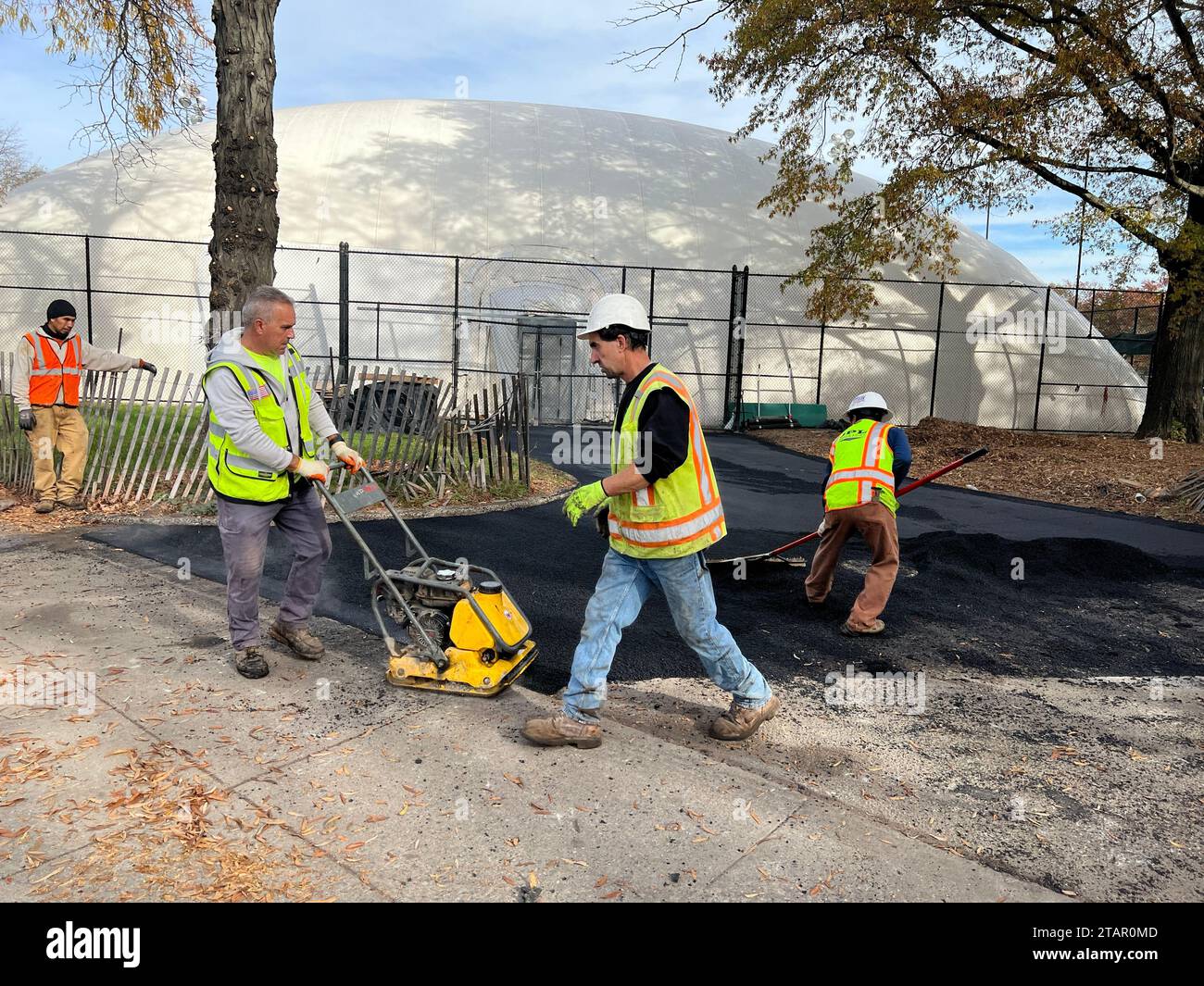 Workers put down new asphalt on a road at the Parade Grounds by ...