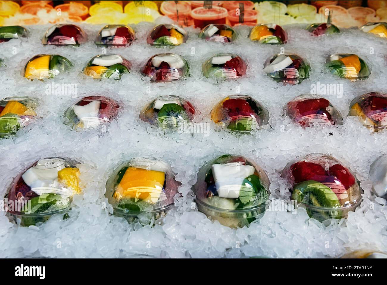 Freshly cut and ready-to-cook fruit in plastic cups, covered with ice ...