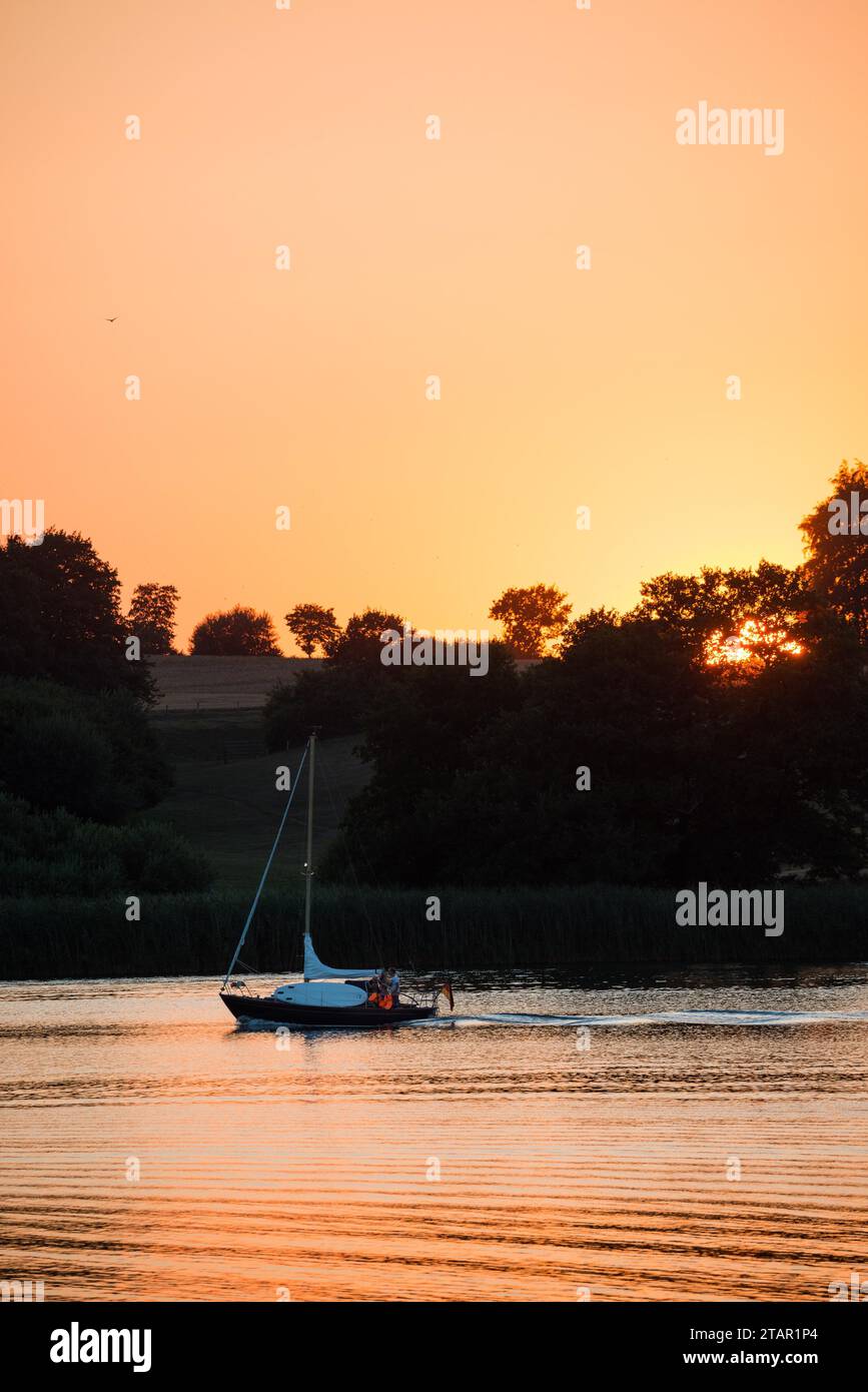 Four people, a family of four motoring across the water of the Schlei ...
