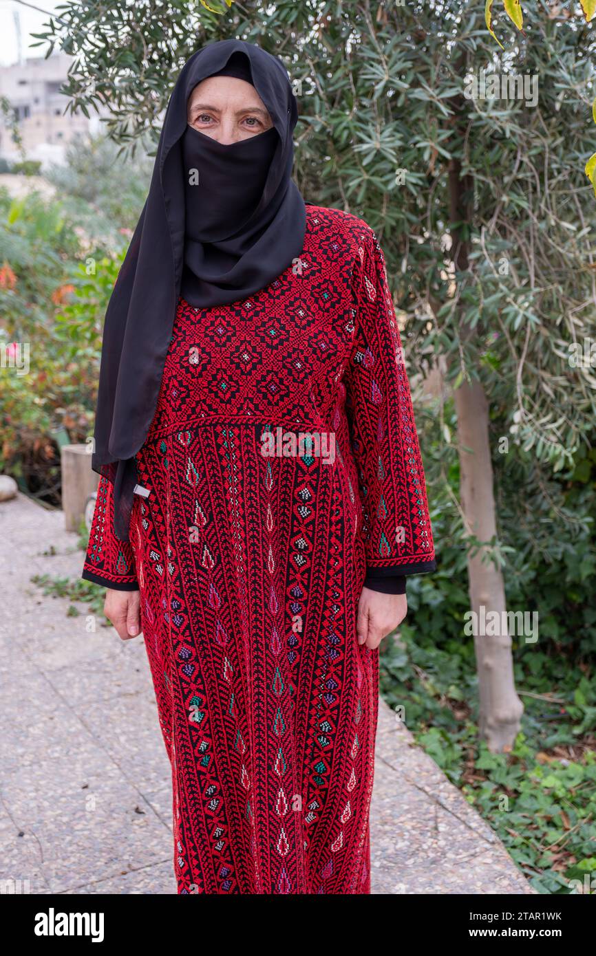 Portrait for woman wearing traditional clothes in refugee camp behinde ...