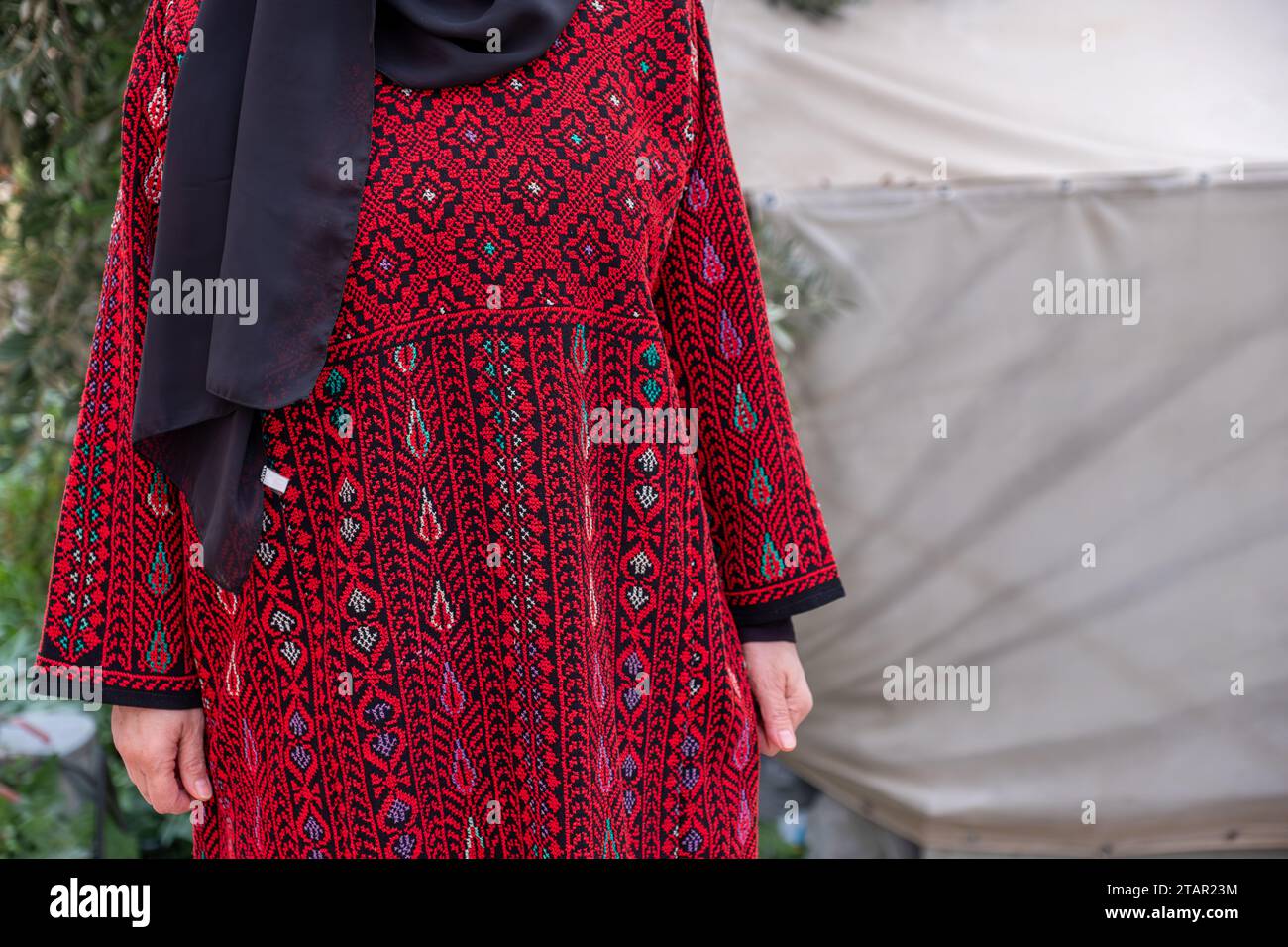 Portrait for woman wearing traditional clothes in refugee camp behinde ...