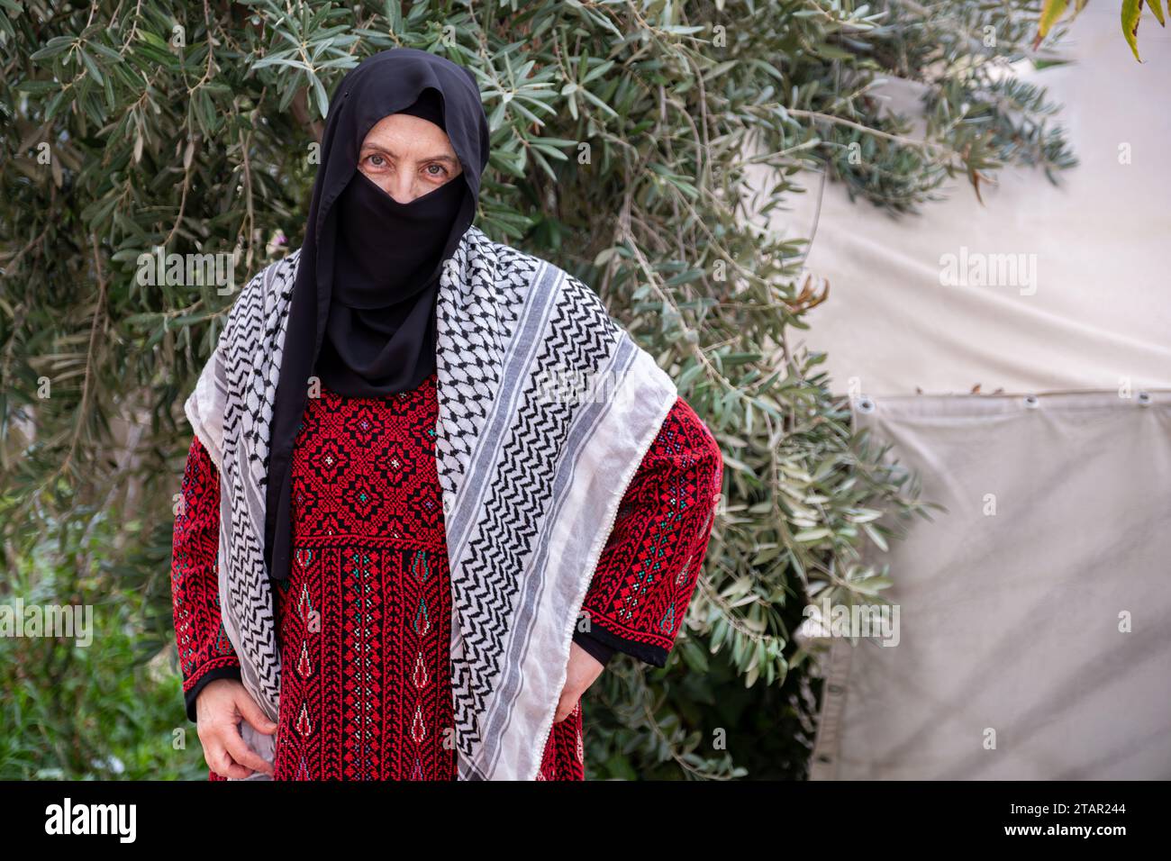 Portrait for woman wearing traditional clothes in refugee camp behinde ...