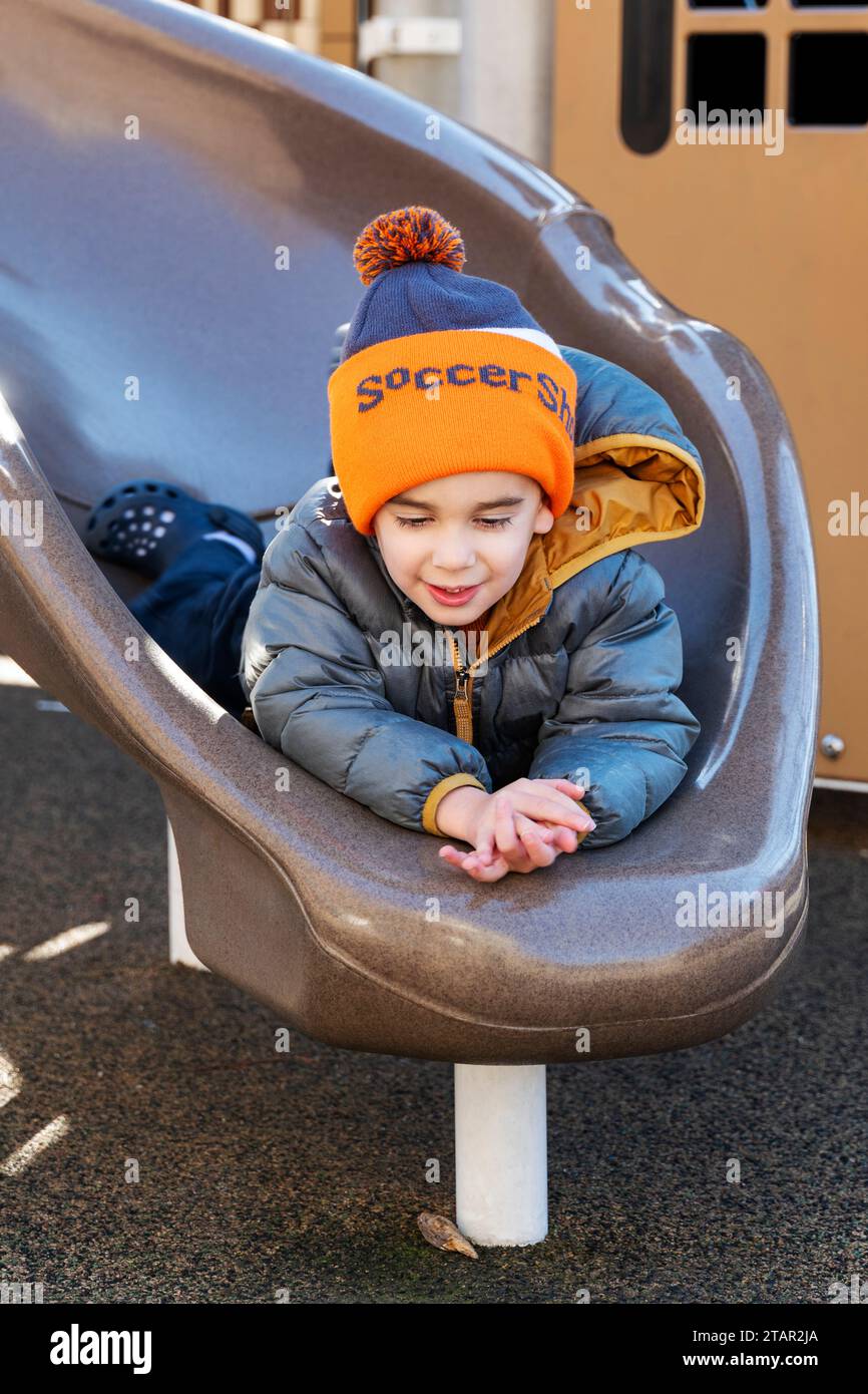 Young child playing on sliding board; outdoors playground; Philadelphia ...