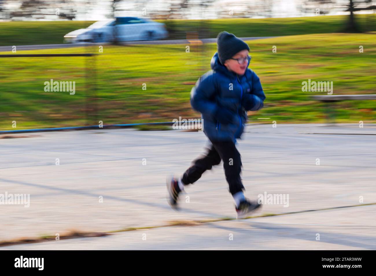 Autumn pan motion blur of young boy running on playground; Philadelphia ...