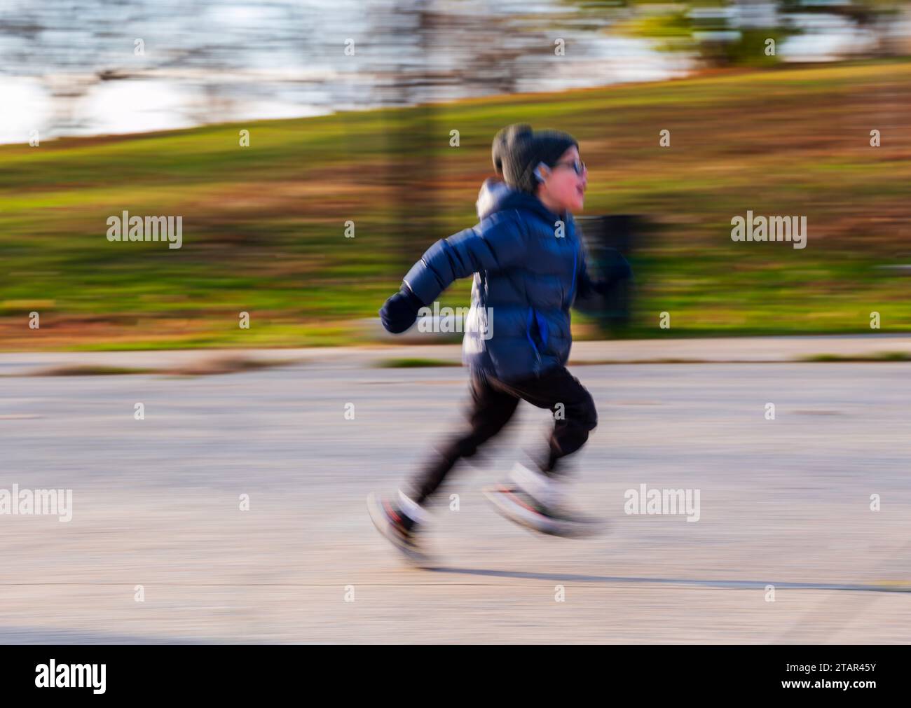 Autumn pan motion blur of young boy running on playground; Philadelphia ...