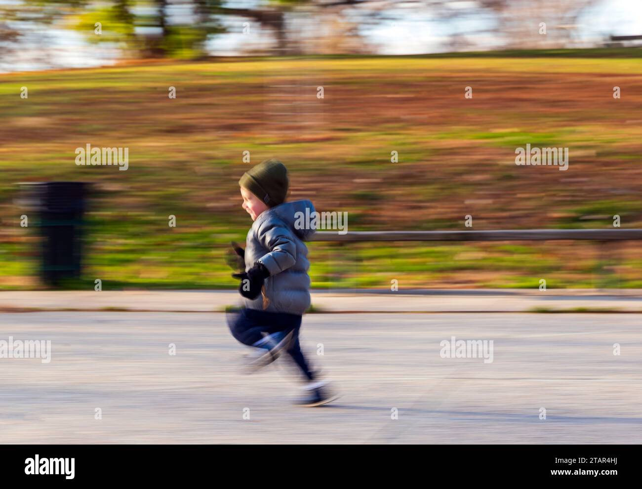 Autumn pan motion blur of young boy running on playground; Philadelphia ...